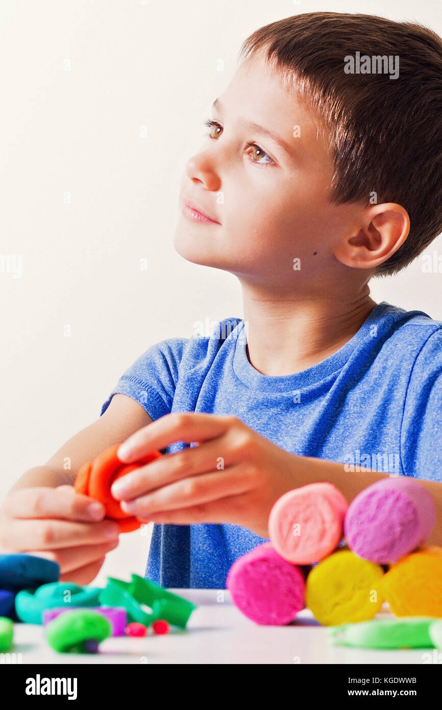 Boy playing and creating from modeling clay or plasticine Stock Photo ...