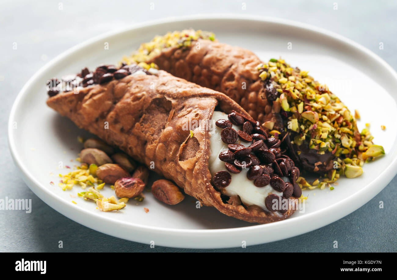 Cannoli with ricotta, chocolate and pistachios. Italian pastries of the ...