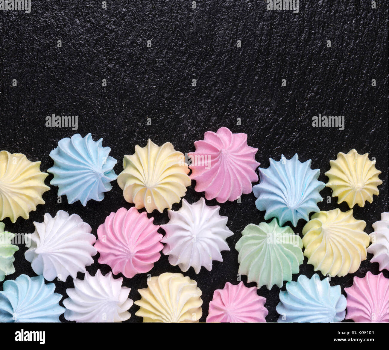 Homemade colour meringue on black plate background. top view Stock ...