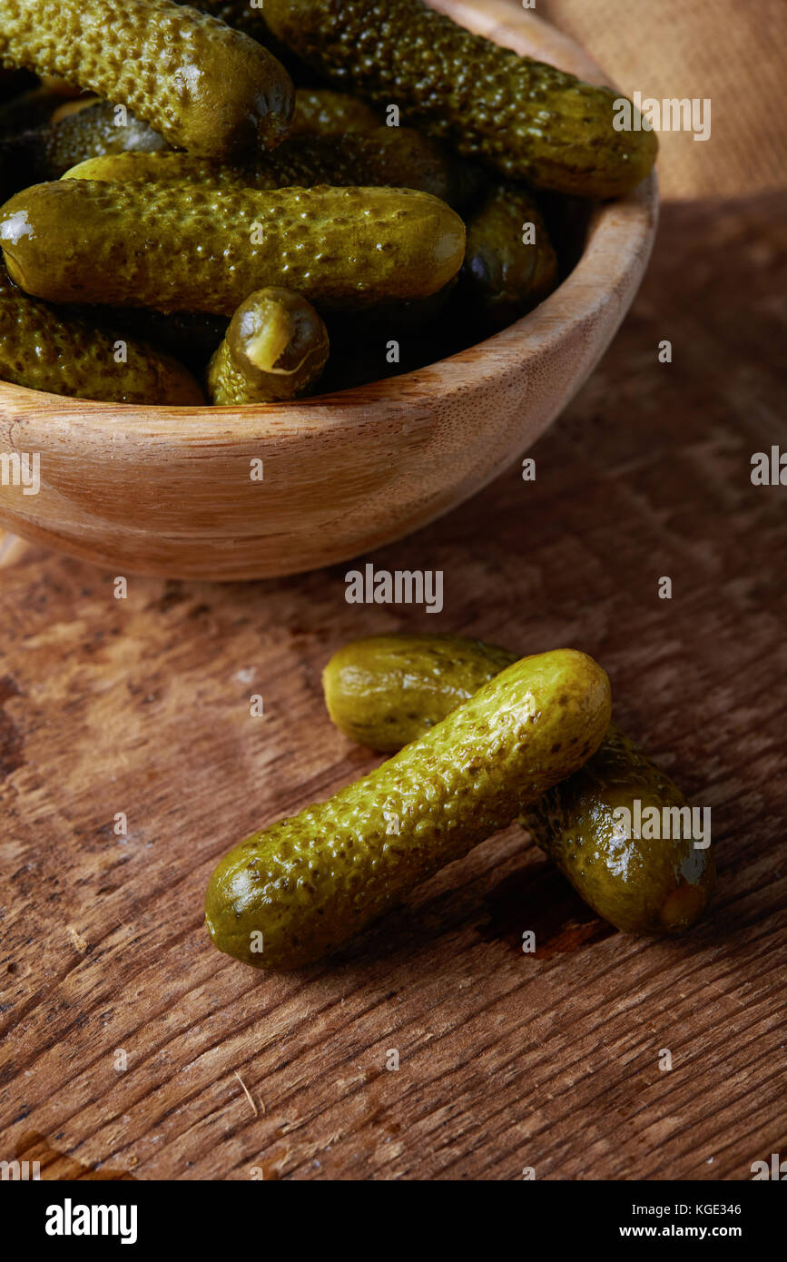 pickled cucumbers in bowl over wooden background Stock Photo - Alamy