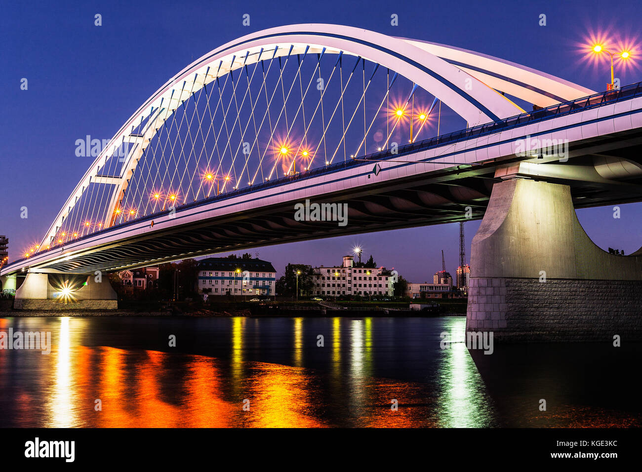 Illuminated Apollo bridge with lights reflection on surface of Danube ...