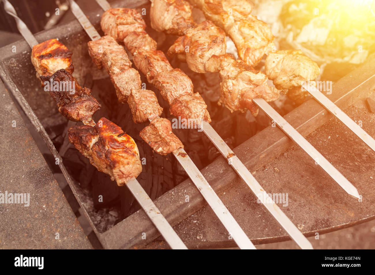 Grilled kebab cooking on metal skewer. Roasted meat cooked at barbecue ...