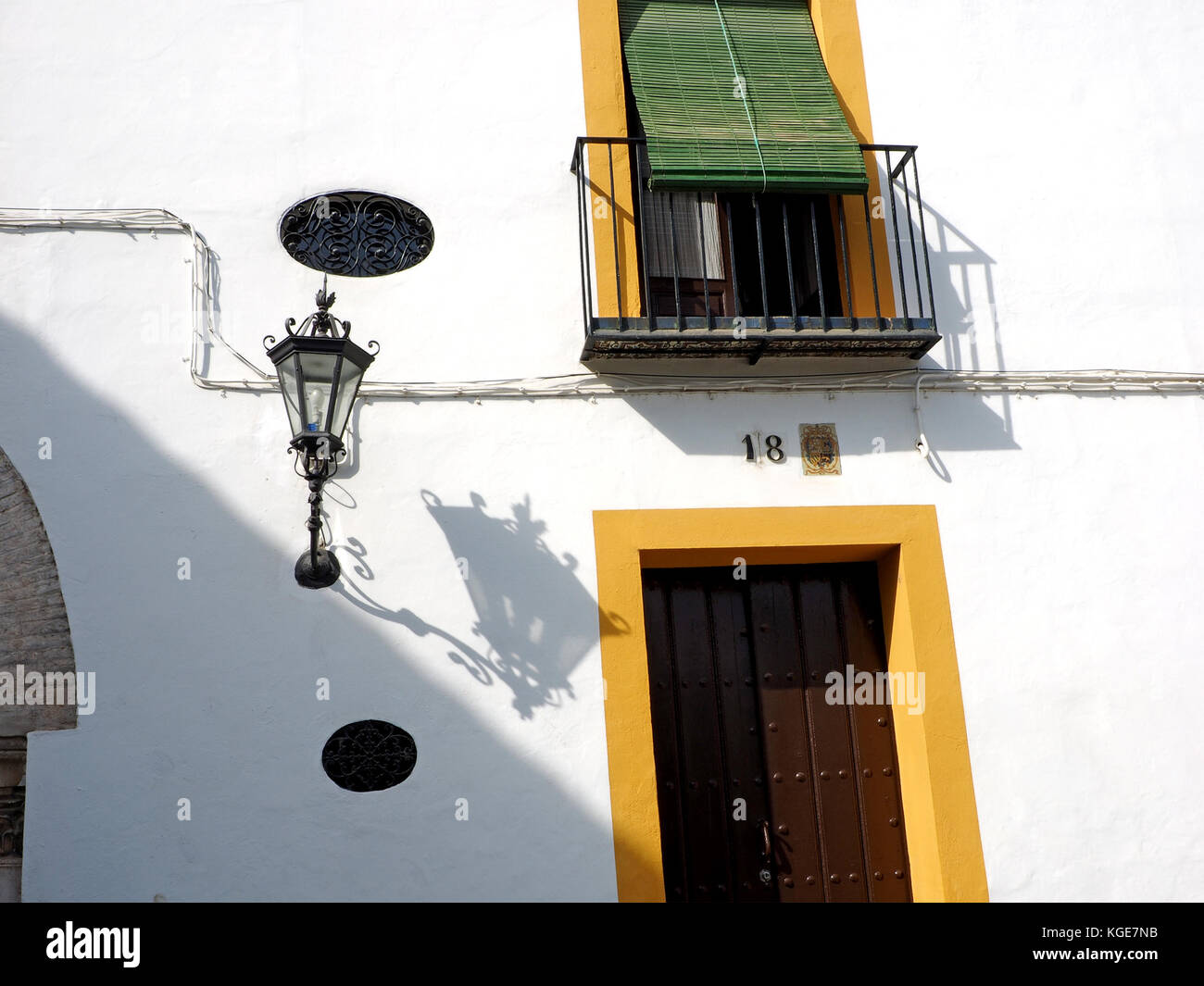 shadow of elaborate lantern on white painted wall with shuttered ...