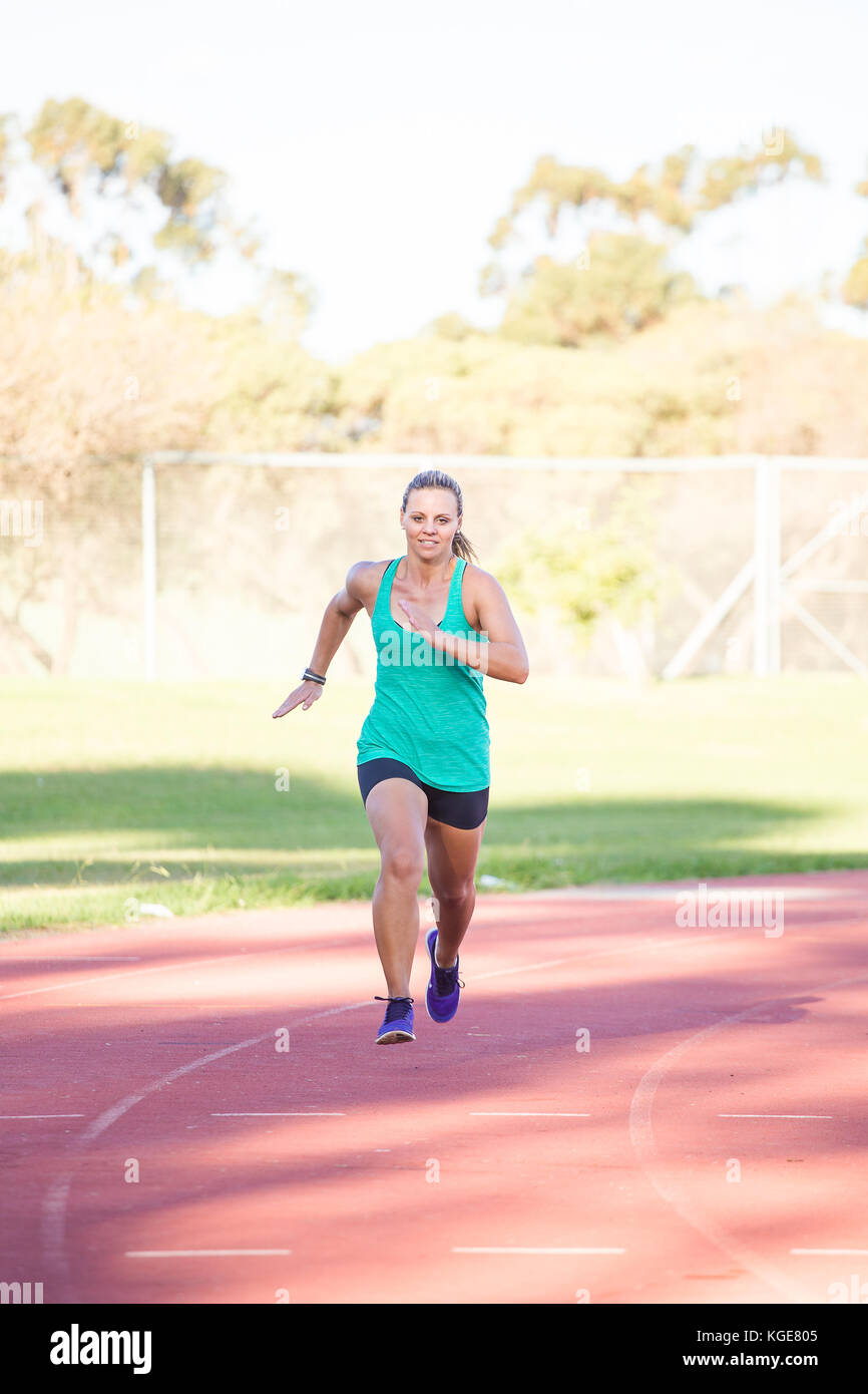 Close up wide angle view of a female sprinter athlete getting ready to ...