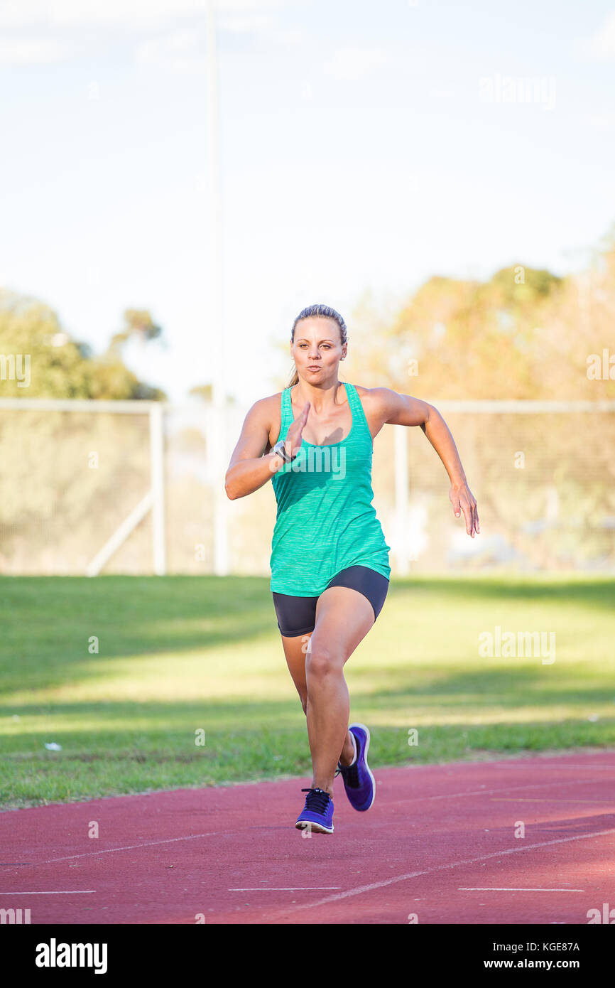 Close up wide angle view of a female sprinter athlete getting ready to ... Close up wide angle view of a female sprinter athlete getting ready to ...