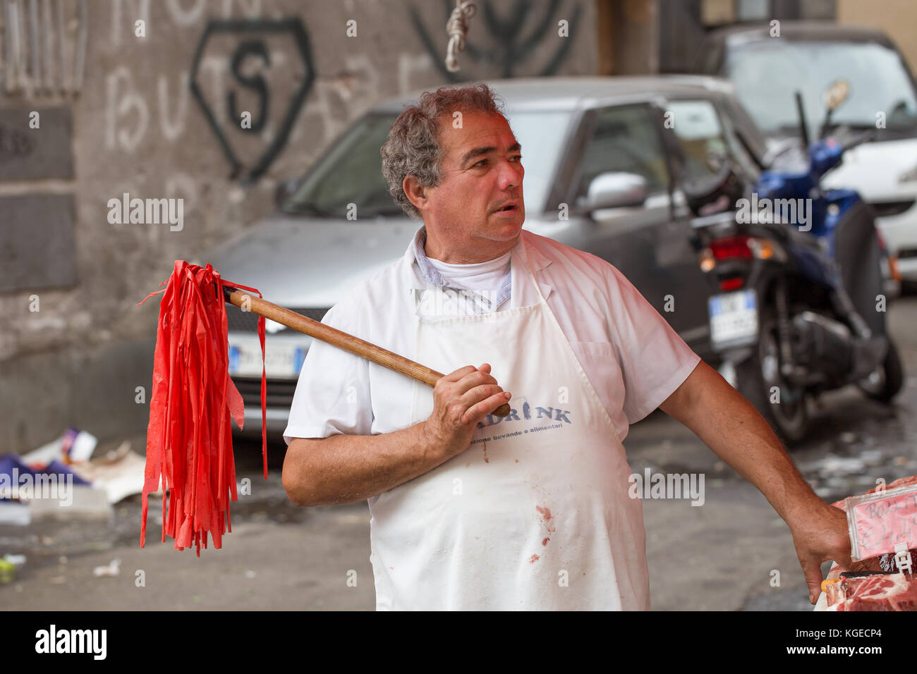 Man selling meat, butcher, slaughterer chasing away the flies and ...