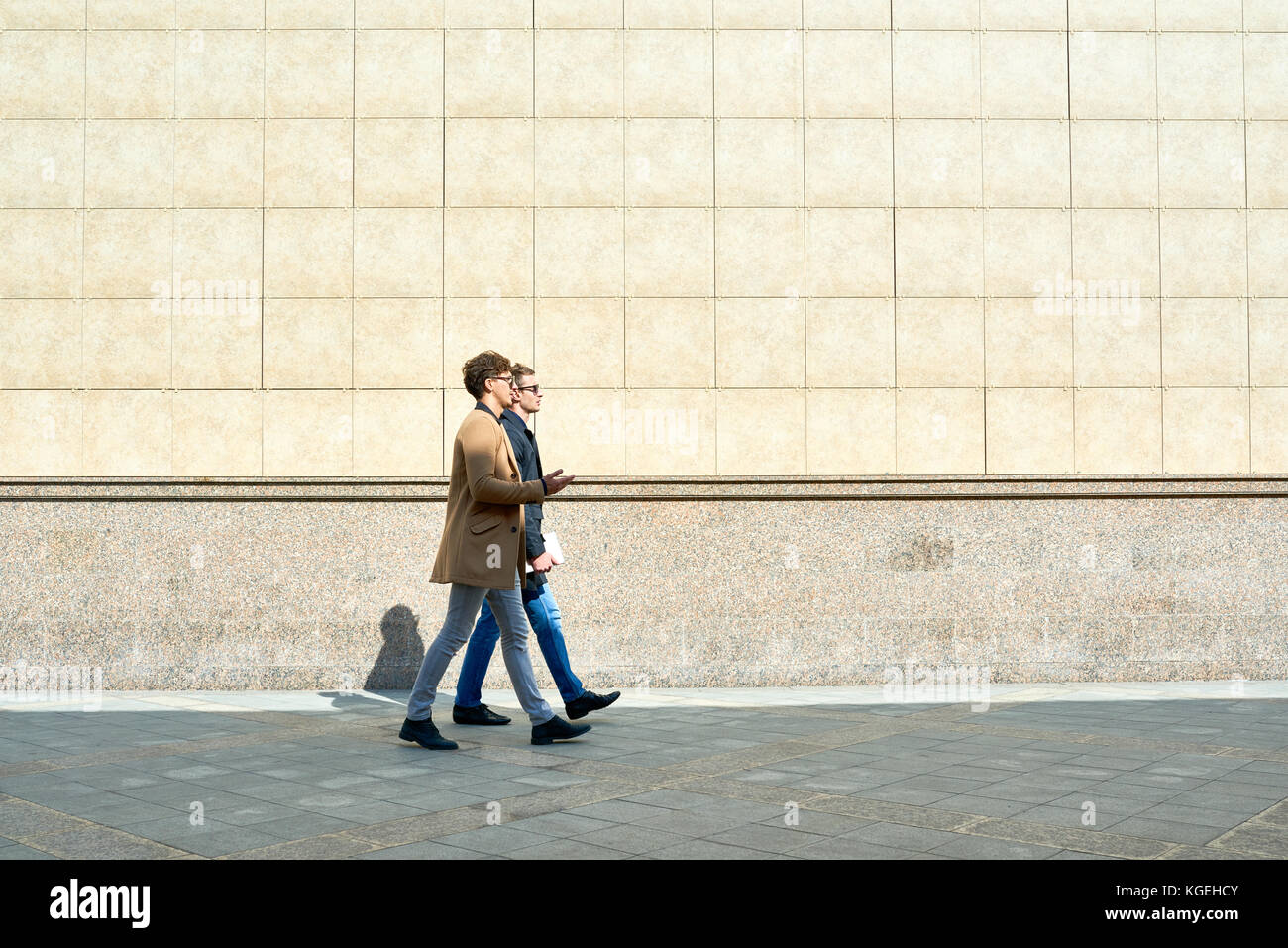 Side view portrait of two modern handsome men wearing autumn coats ...
