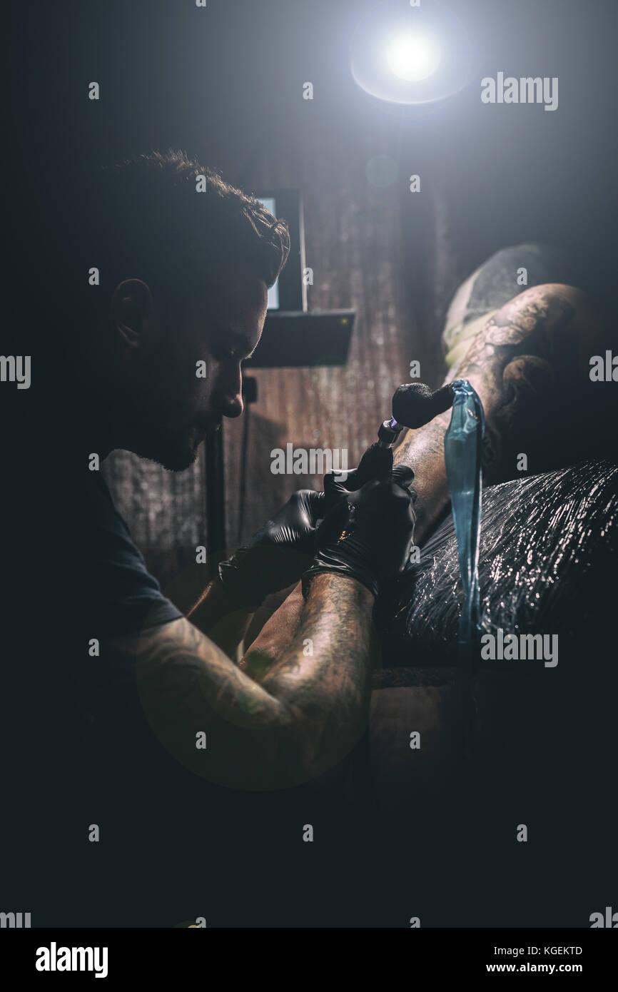 Tattoo master tattooing mans hand hi-res stock photography and images ...