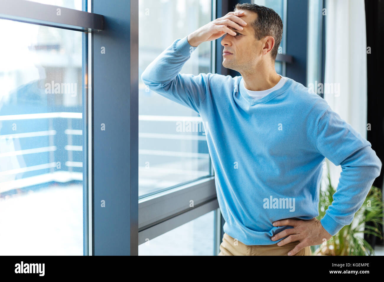 Sad moody man looking into the window Stock Photo - Alamy