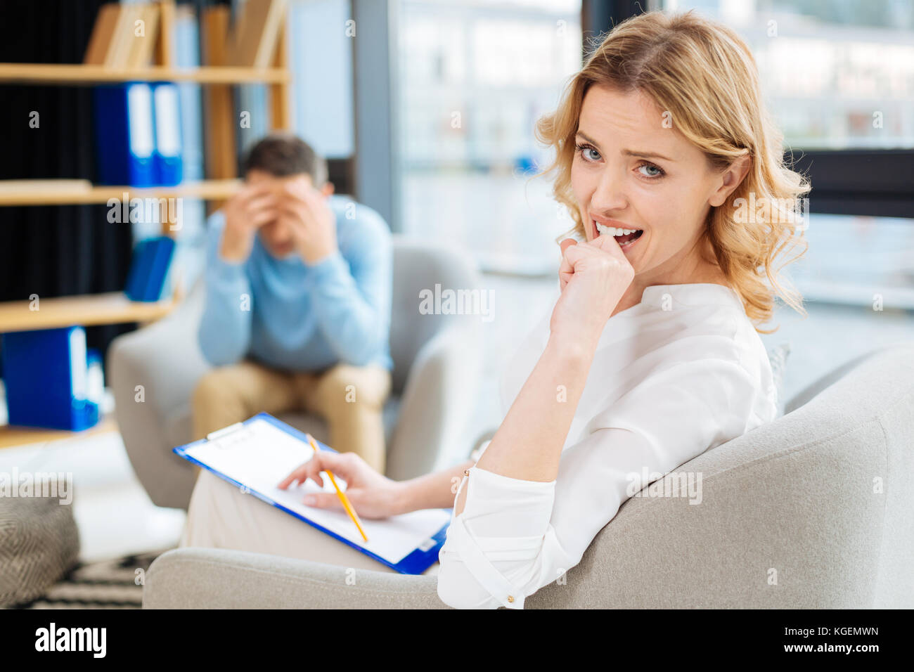 Pleasant nice woman biting her hand Stock Photo - Alamy