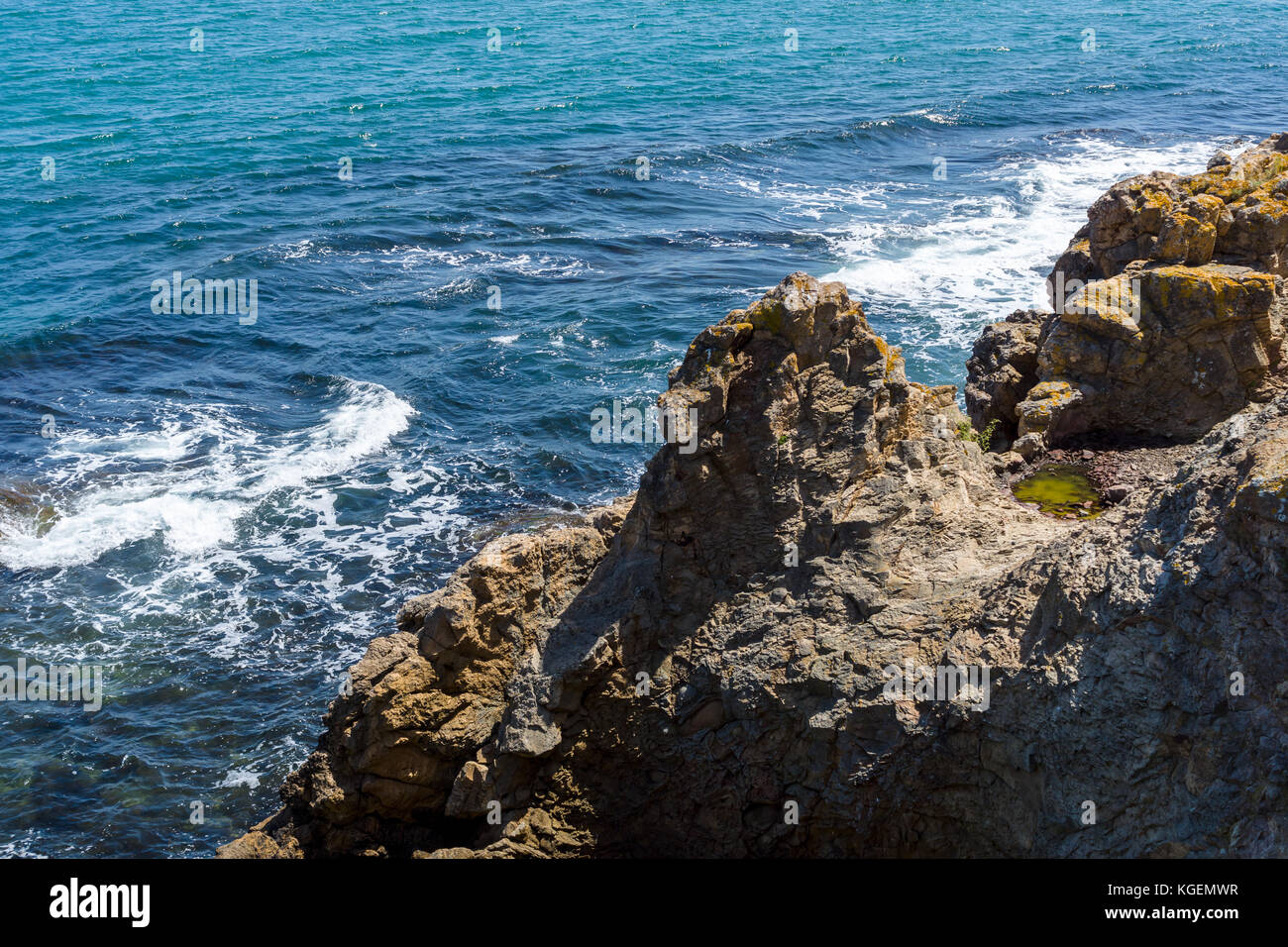 Blue sea, waves and rocky shore Stock Photo - Alamy