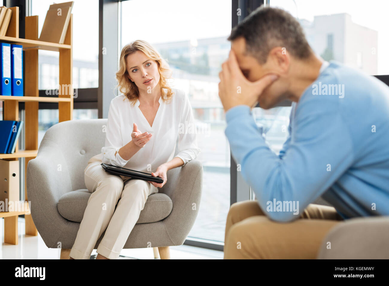 Smart nice woman looking at her patient Stock Photo - Alamy