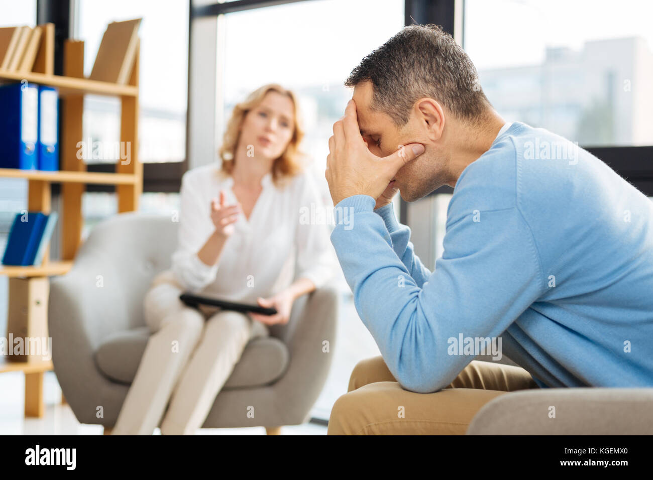 Cheerless depressed man covering his face Stock Photo - Alamy