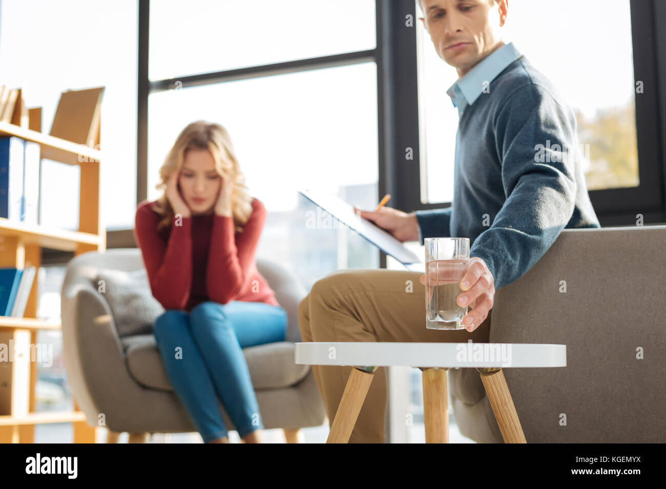 Sad cheerless man taking a glass of water Stock Photo - Alamy