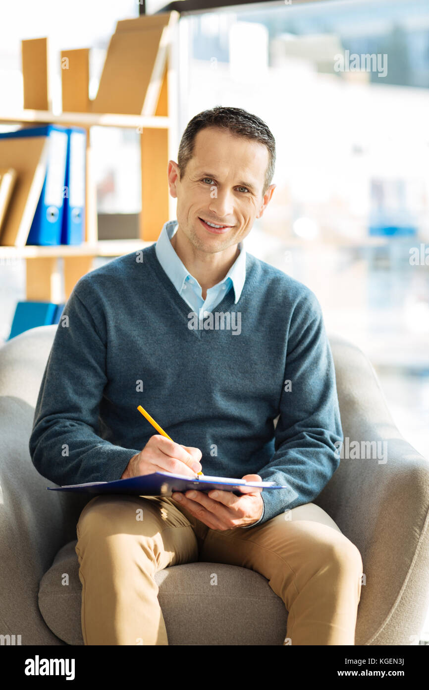 Cheerful happy man sitting in the armchair Stock Photo - Alamy