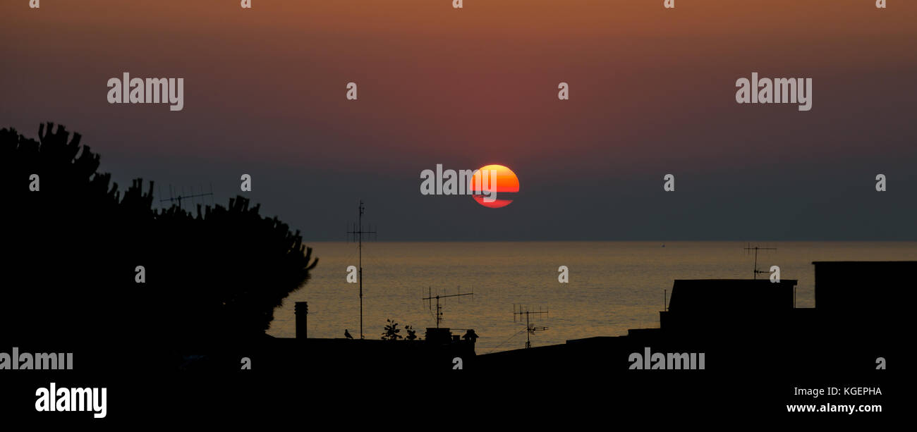 Big round red and orange sun go down in the sea Stock Photo - Alamy