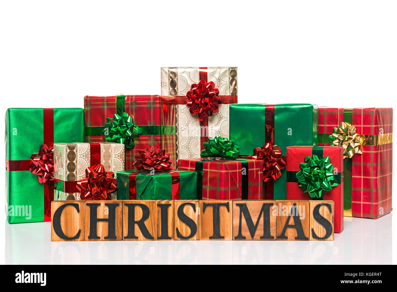 The word Christmas in wooden letters in front of gift wrapped presents ...