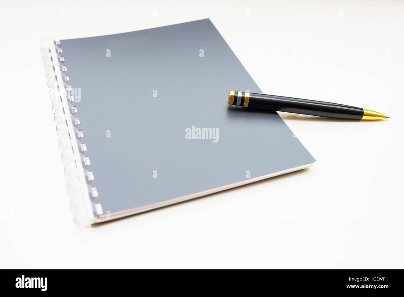 Notebook on gray springs and black pen on a white background Stock ...