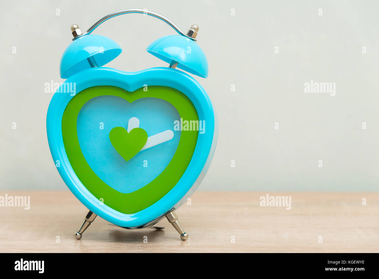 Green-blue clock standing on a wooden background Stock Photo - Alamy