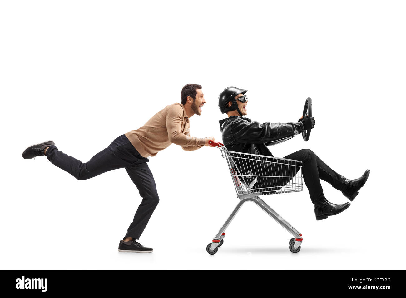 Young man pushing a shopping cart with a biker riding inside and ...