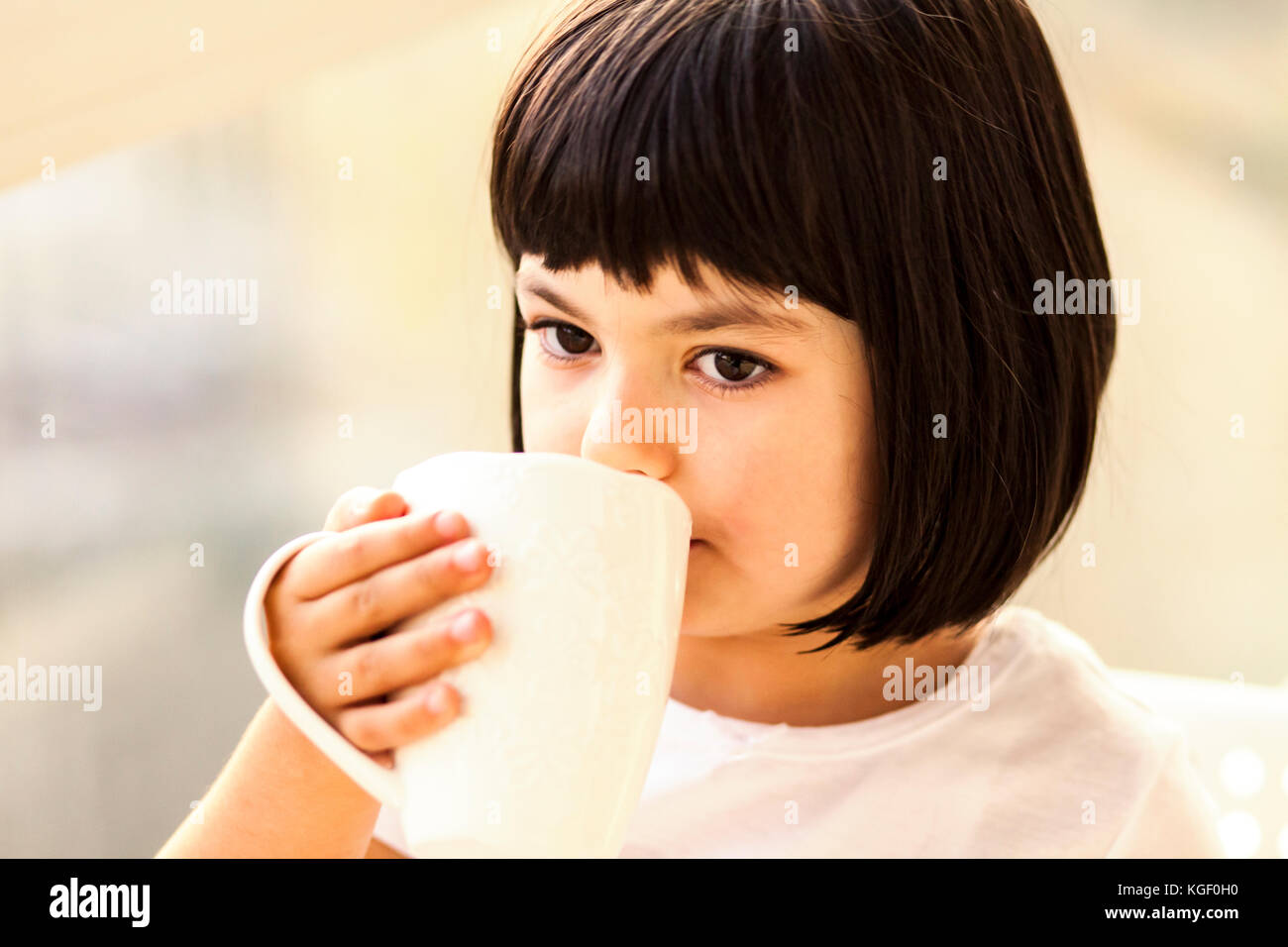 Portrait of pittle girl drinking milk or tea Stock Photo - Alamy