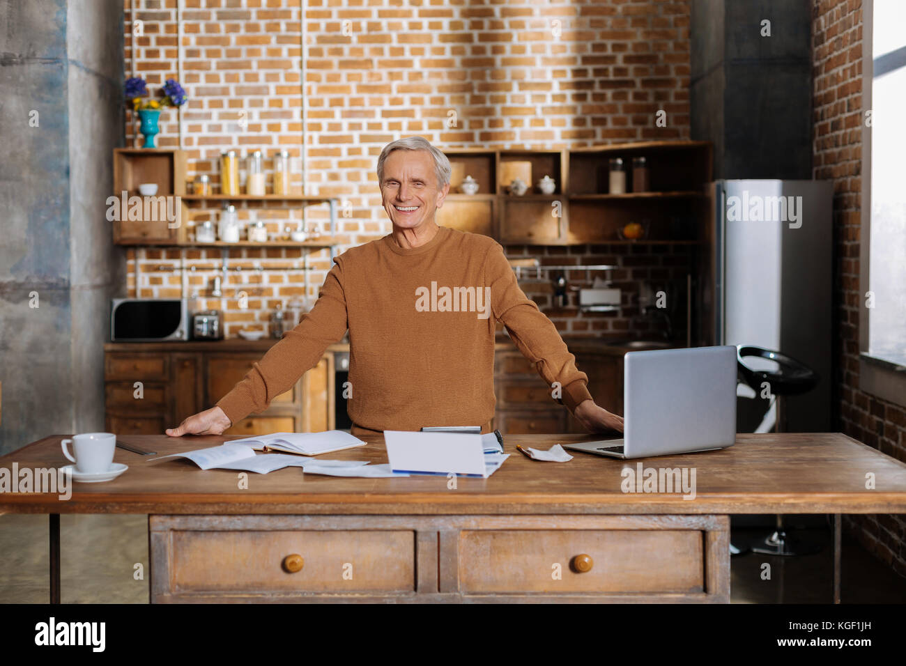 Happy delighted man standing at the table Stock Photo - Alamy