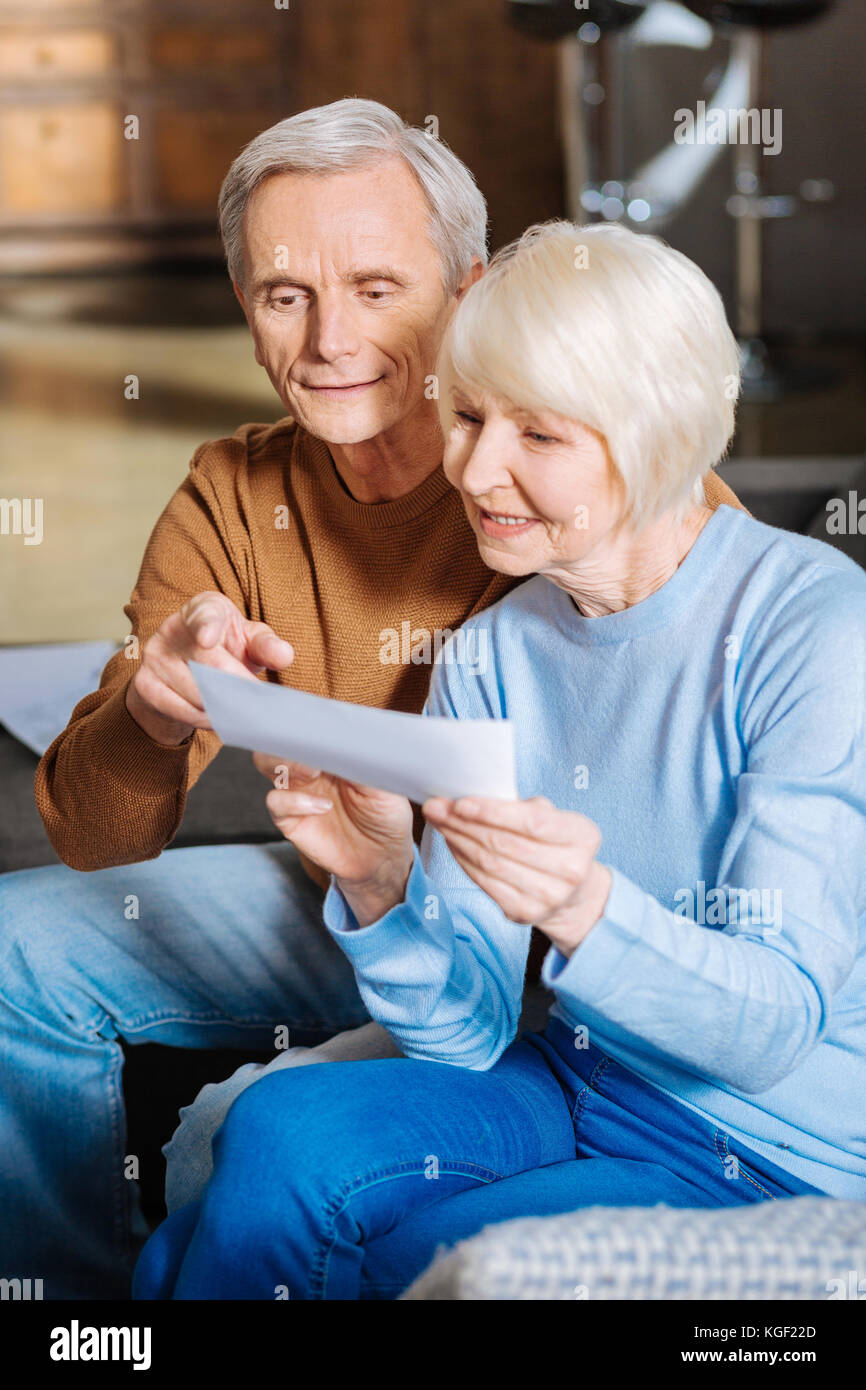 Joyful nice couple looking at the documents Stock Photo - Alamy