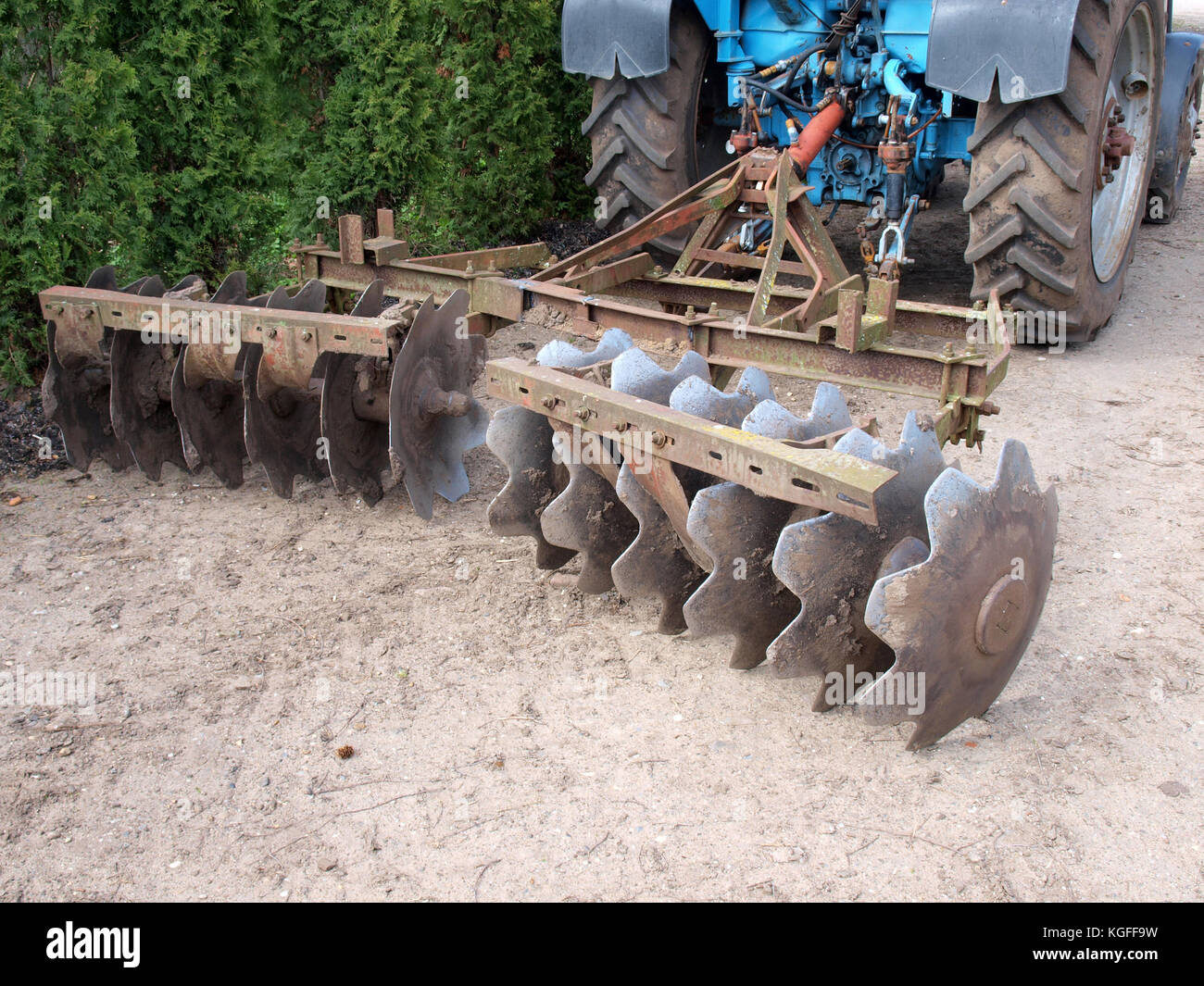 Tractor powered heavy disc harrows on ground Stock Photo - Alamy