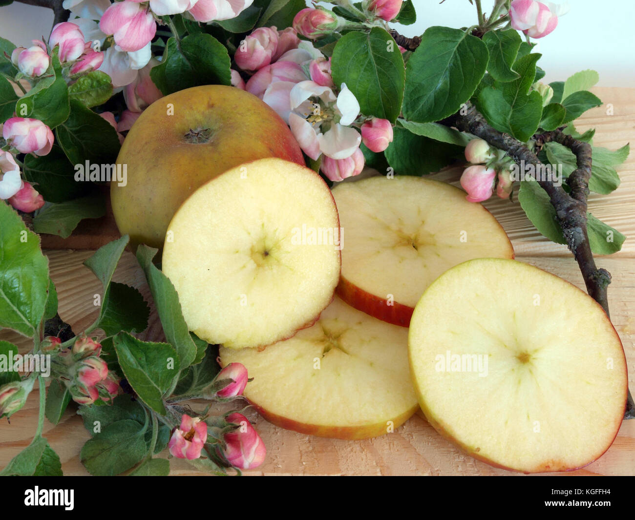 Ripe apples whole and sliced and branch with blossoms Stock Photo - Alamy