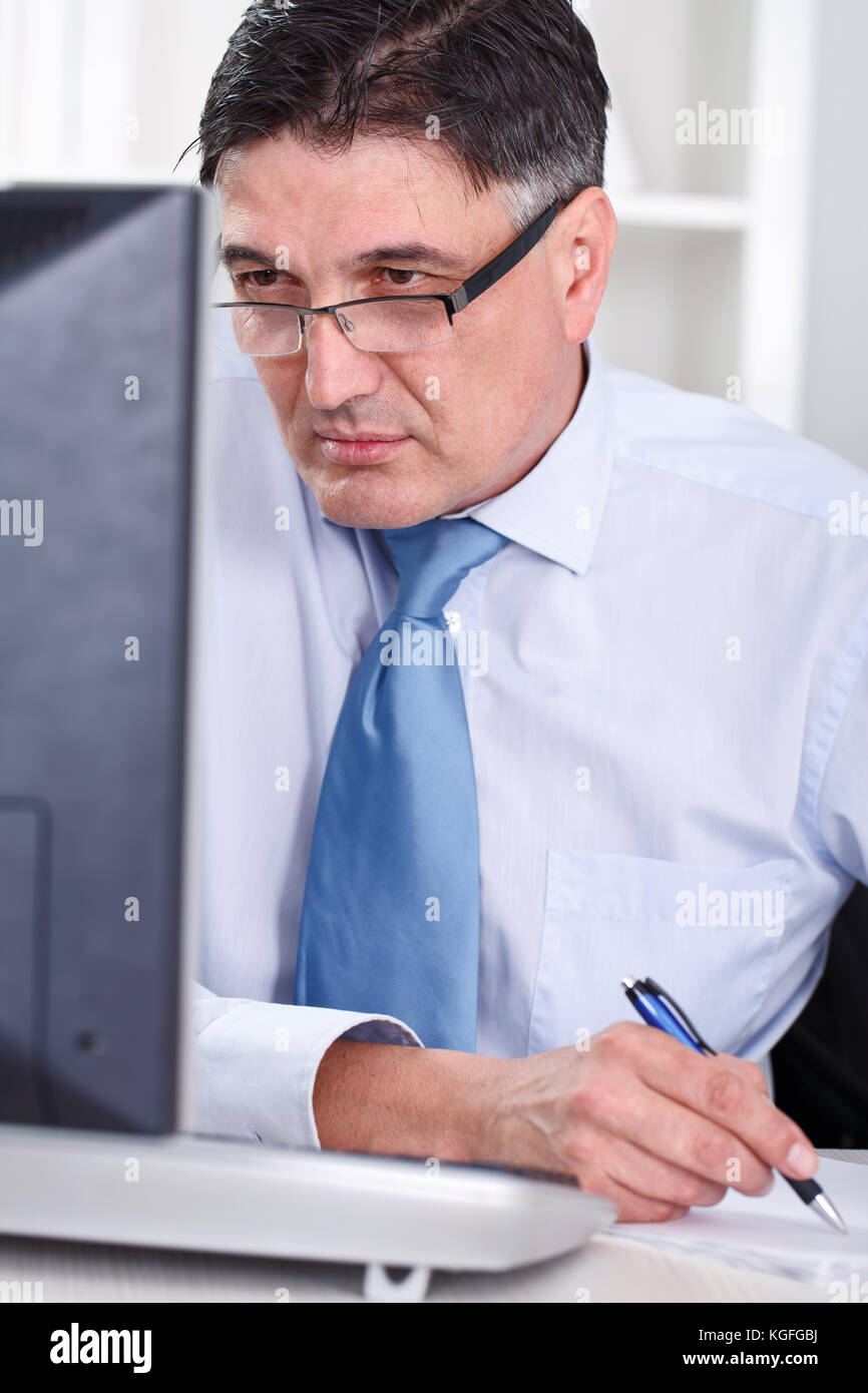 mature business man looking at computer screen and working Stock Photo ...