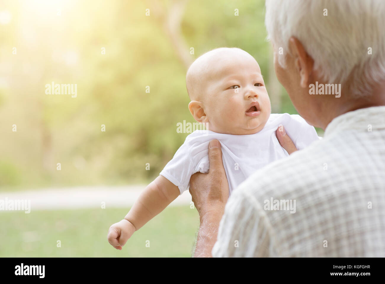 Happy grandfather with baby grandson at outdoors park. Asian family ...