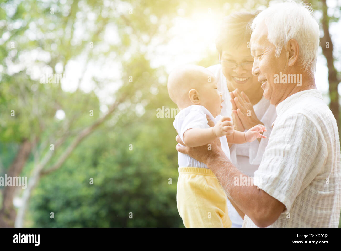 Grandparents holding baby grandson at outdoor park, Asian family, life ...