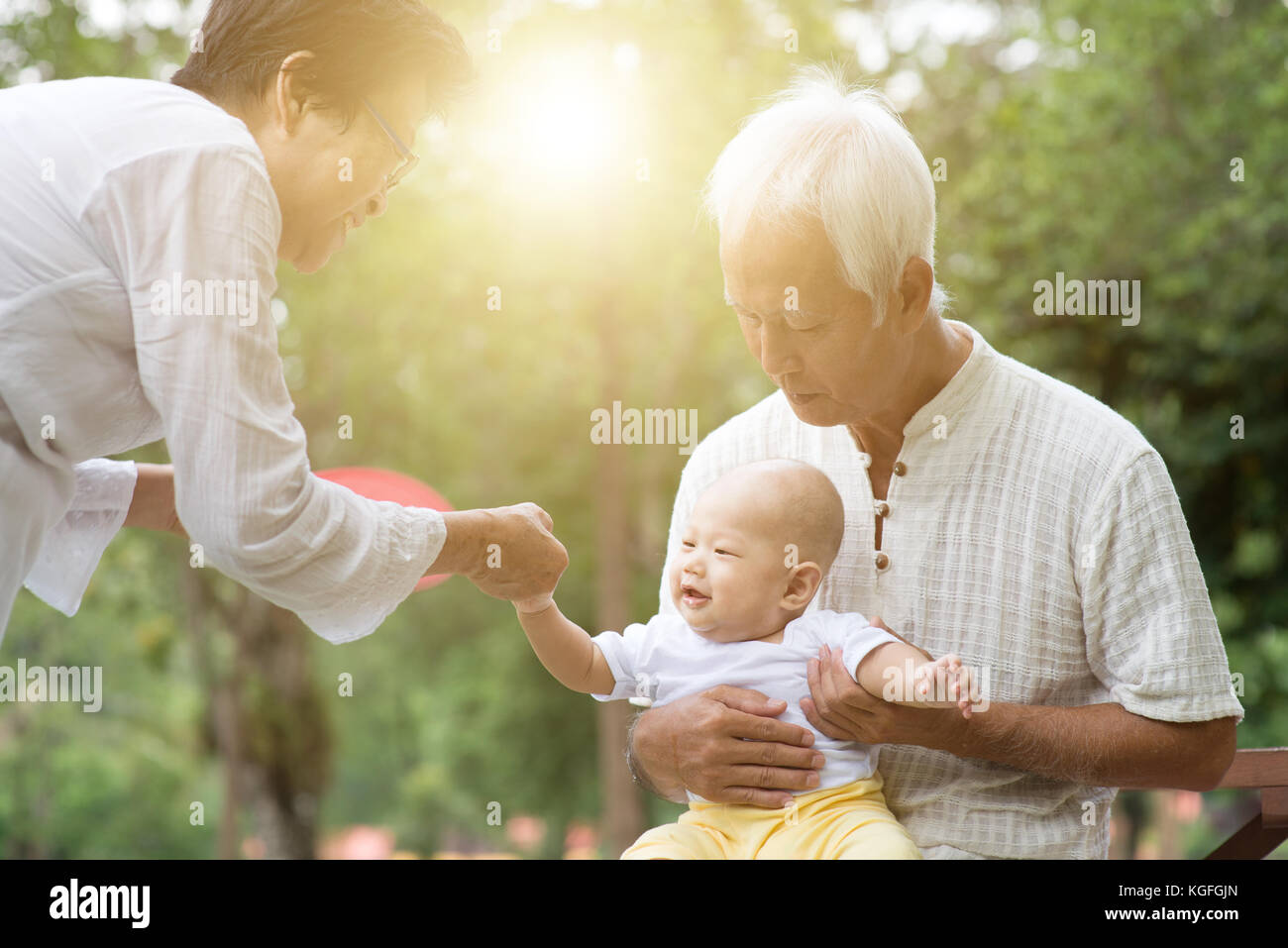 Baby grandson and grandparents having fun outdoors. Asian family, life ...