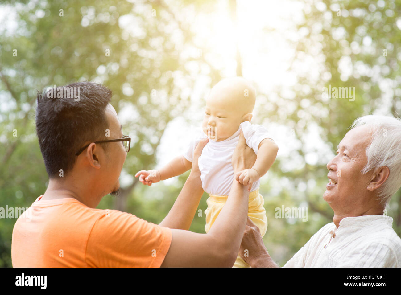 Happy grandfather, father and baby grandson at outdoors park. Asian ...