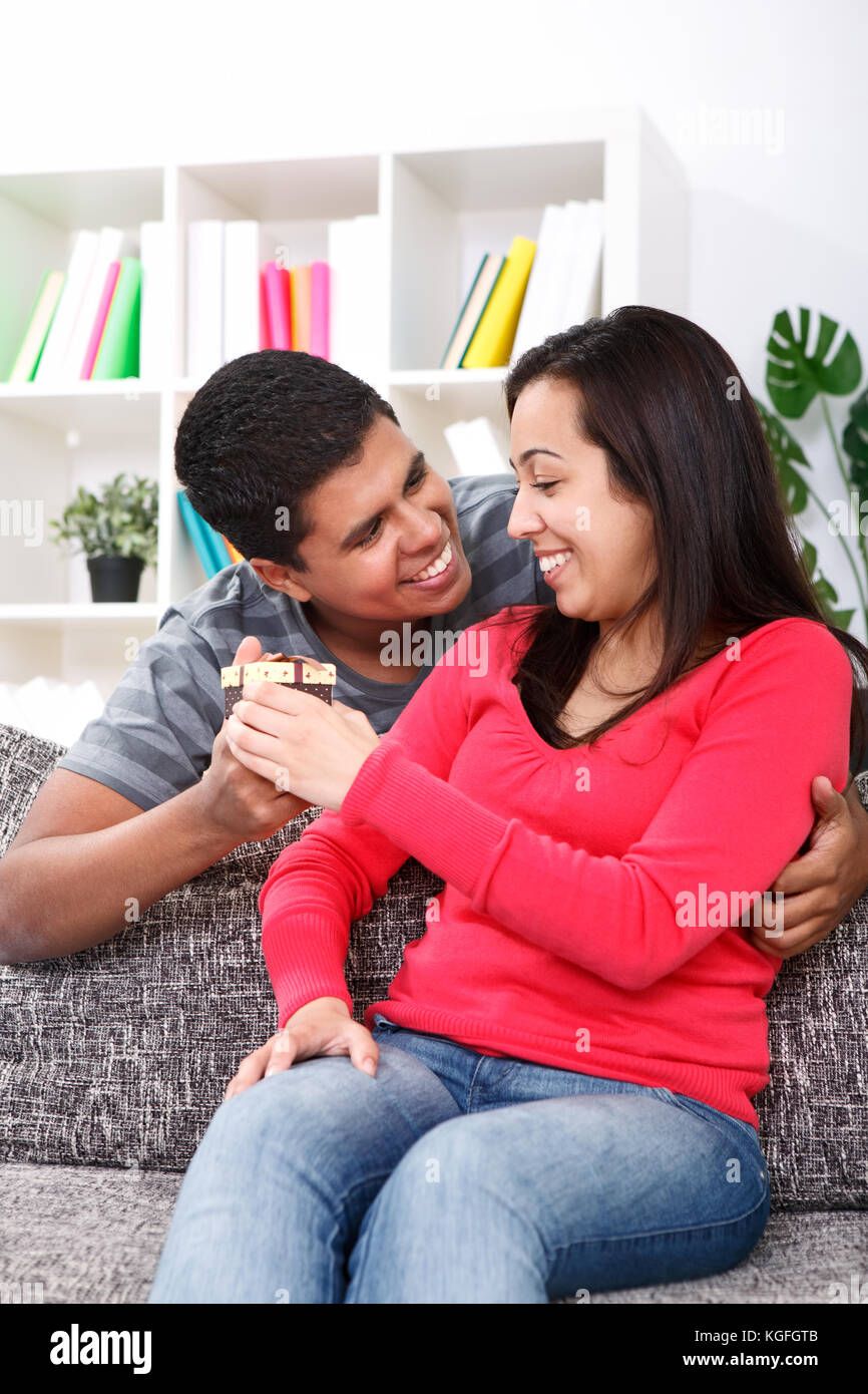 Happy young couple giving surprise gift Stock Photo - Alamy