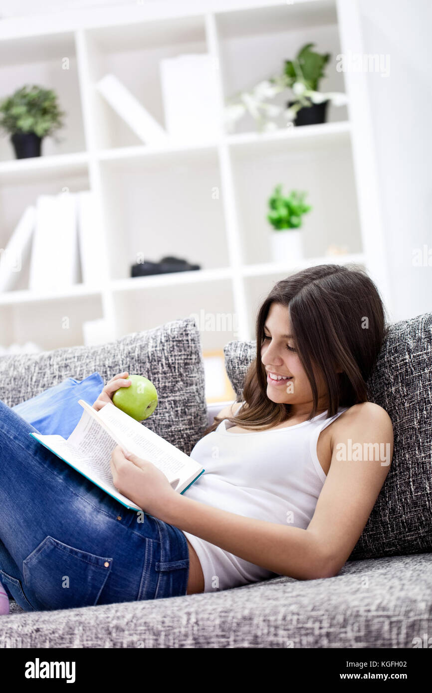 Teenager girl reading on the couch Stock Photo - Alamy