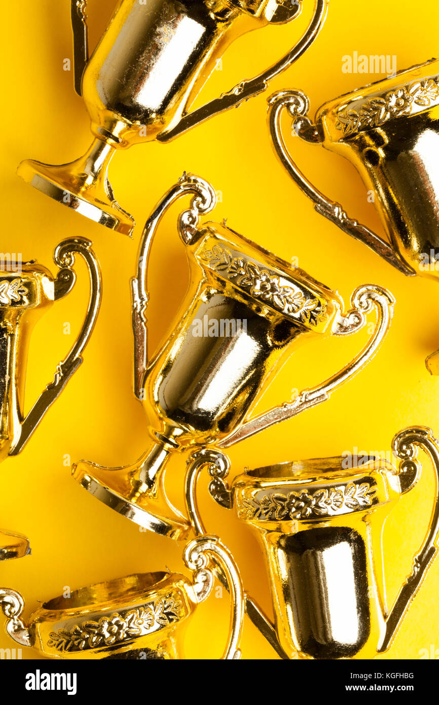 Gold winners achievement trophy on a yellow background Stock Photo - Alamy