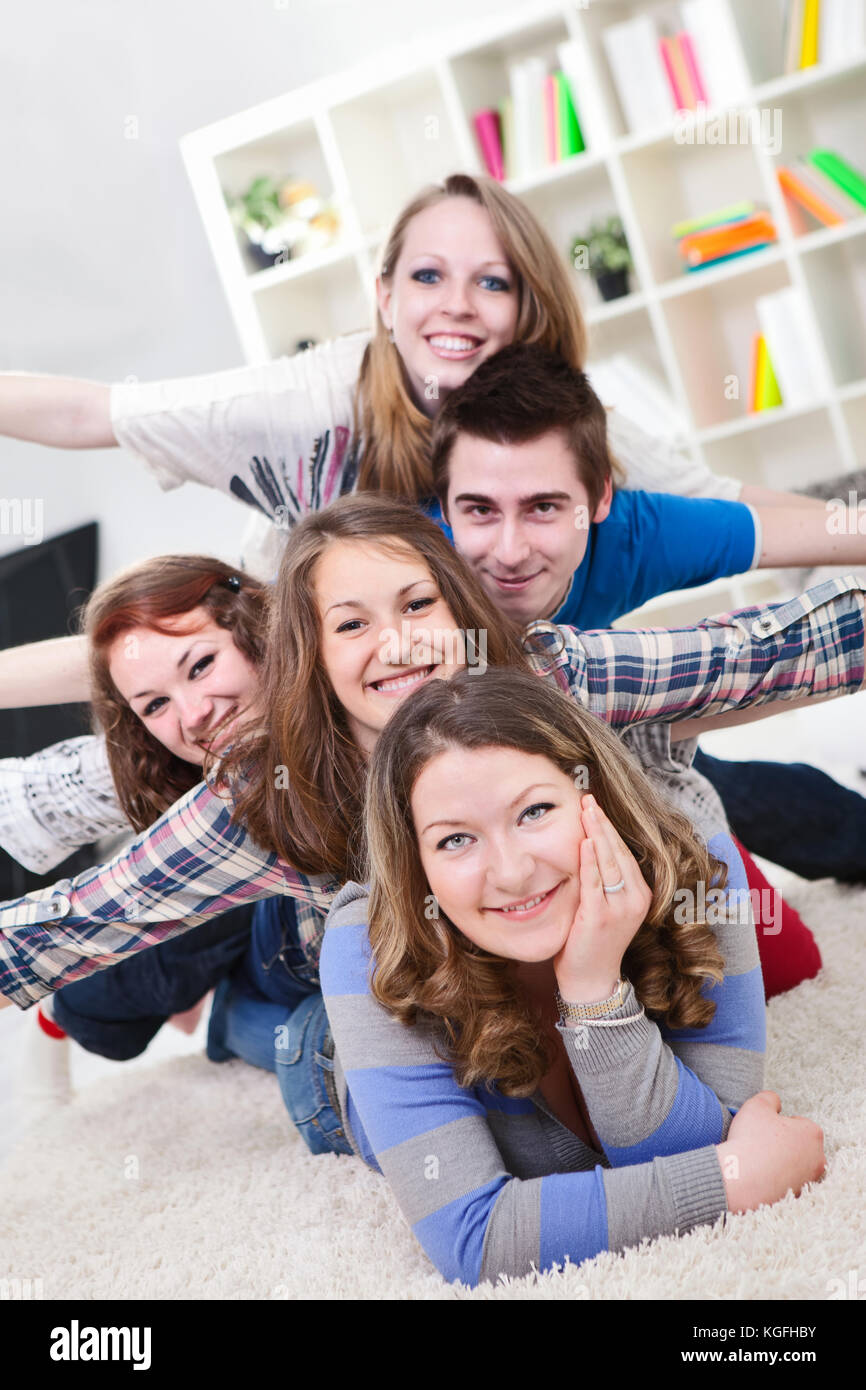 group of teenagers having fun indoor, smiling and looking at camera ...