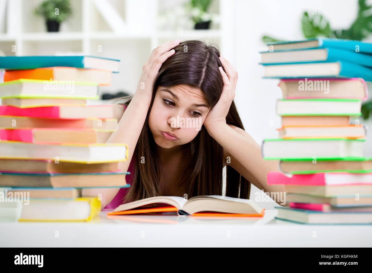 Unhappy teenage girl studying at the desk Stock Photo - Alamy