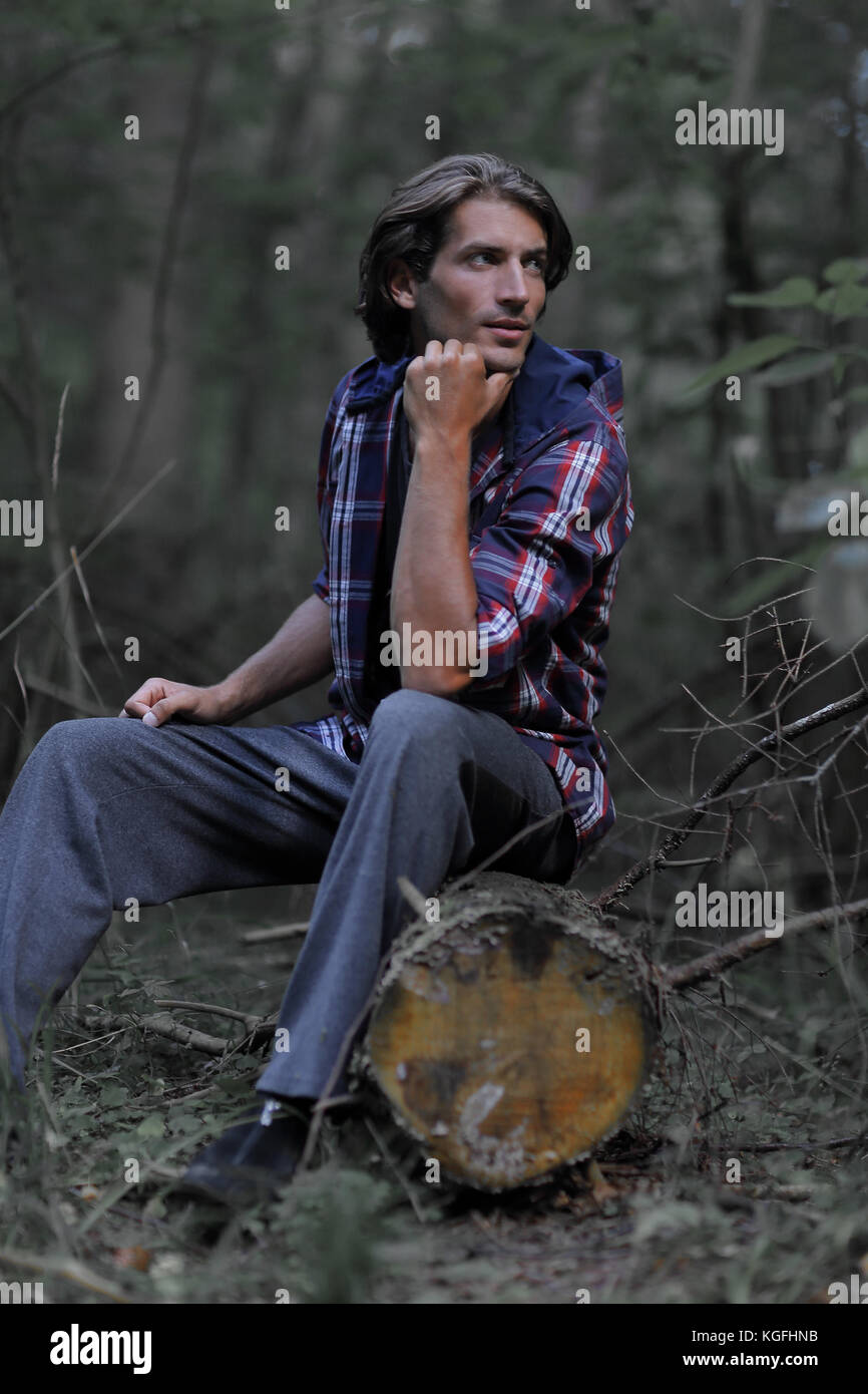 dreaming of a man sitting on a log in the woods Stock Photo - Alamy