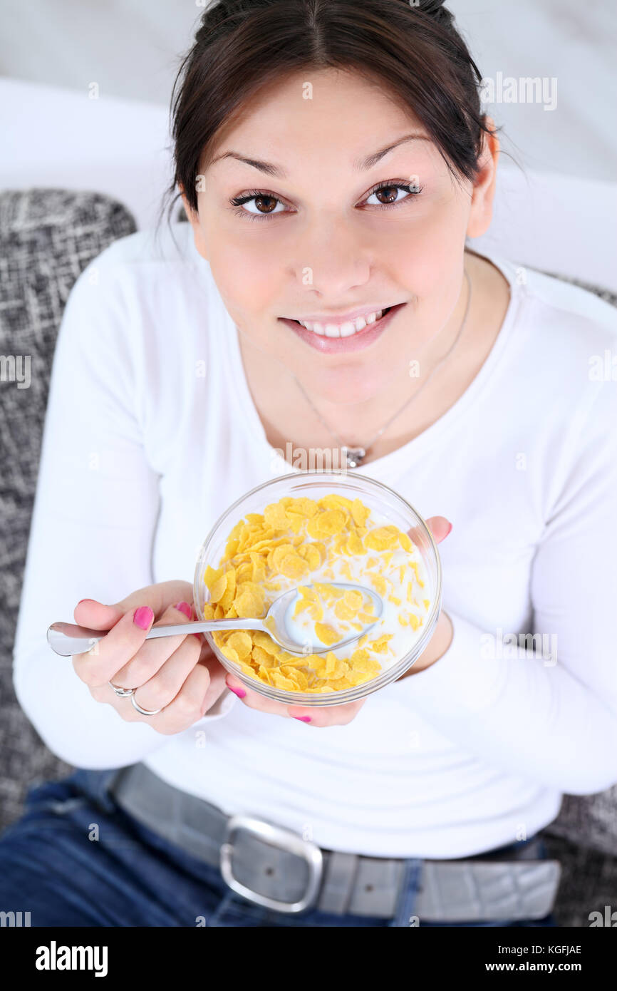 Woman eating breakfast cornflakes, smiling Stock Photo - Alamy