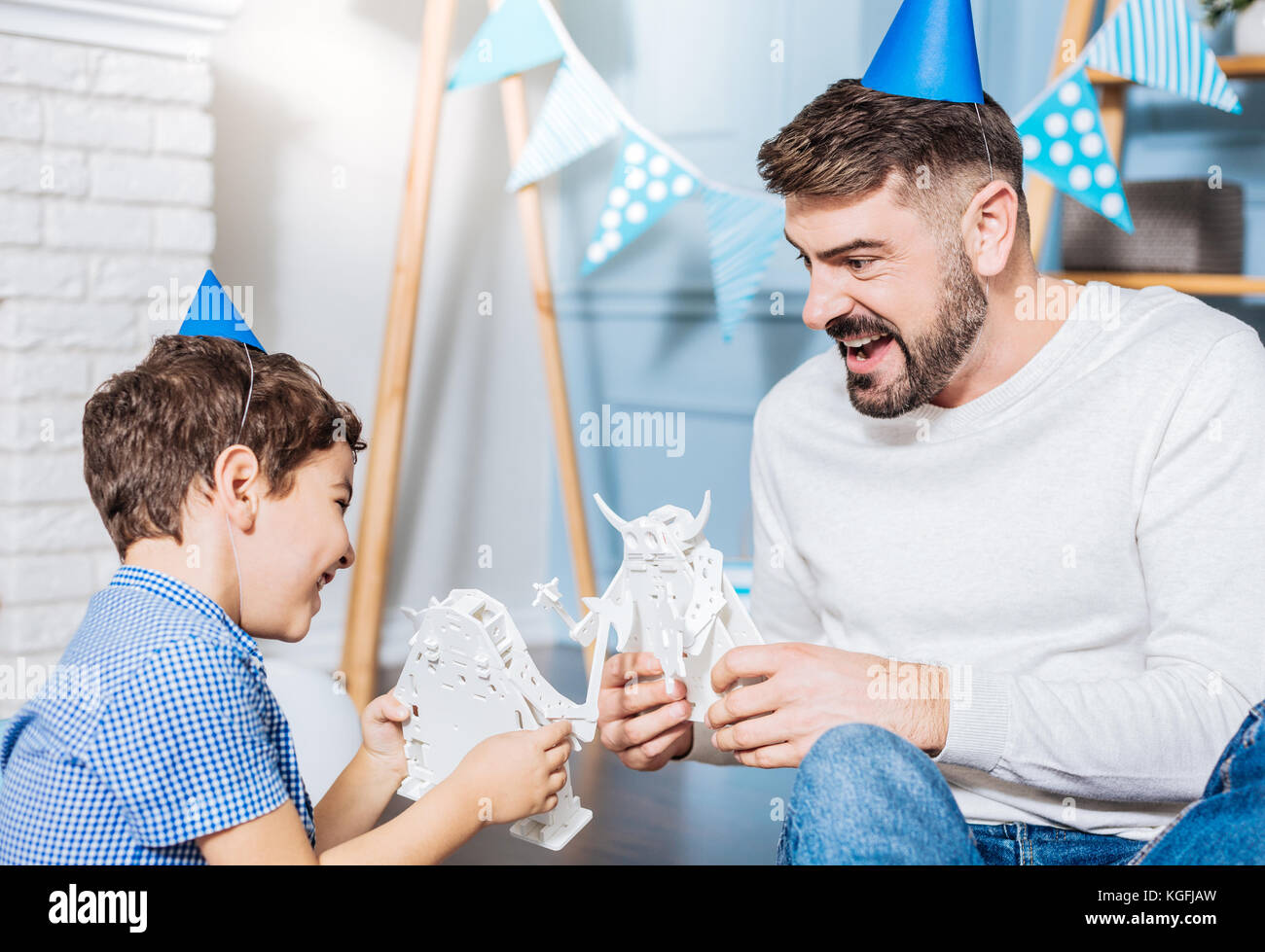 Happy father and son enjoying toy robot fights Stock Photo - Alamy