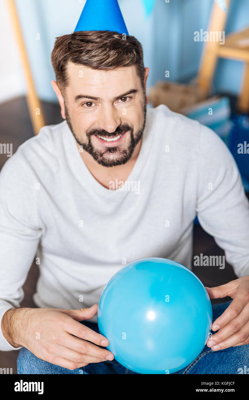 Pleasant young man posing with a blue balloon Stock Photo - Alamy