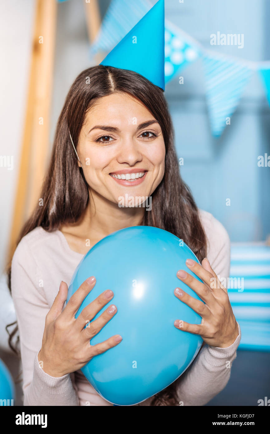 Happy woman pressing balloon to her chest and smiling Stock Photo - Alamy