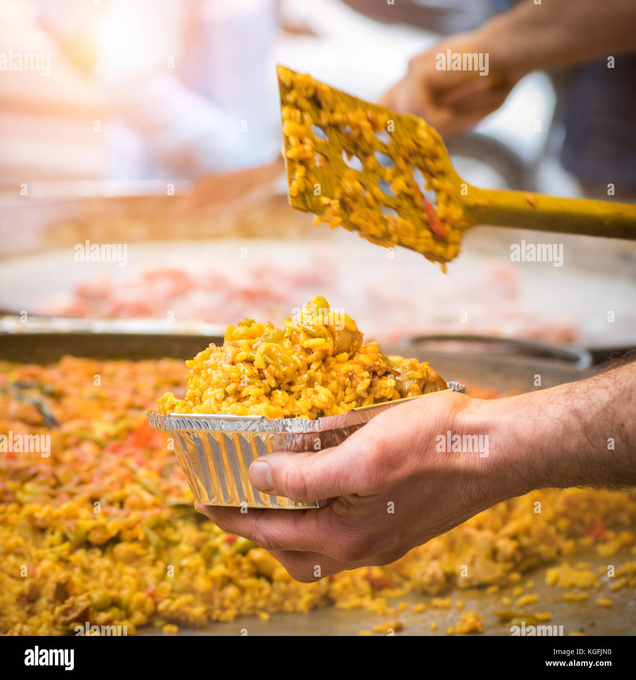 Man serving traditional spanish chicken paella, food market Stock Photo ...
