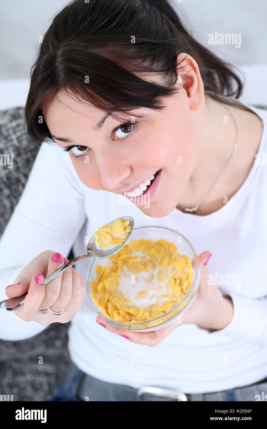 Young beautiful girl eating cornflakes, healthy breakfast Stock Photo ...