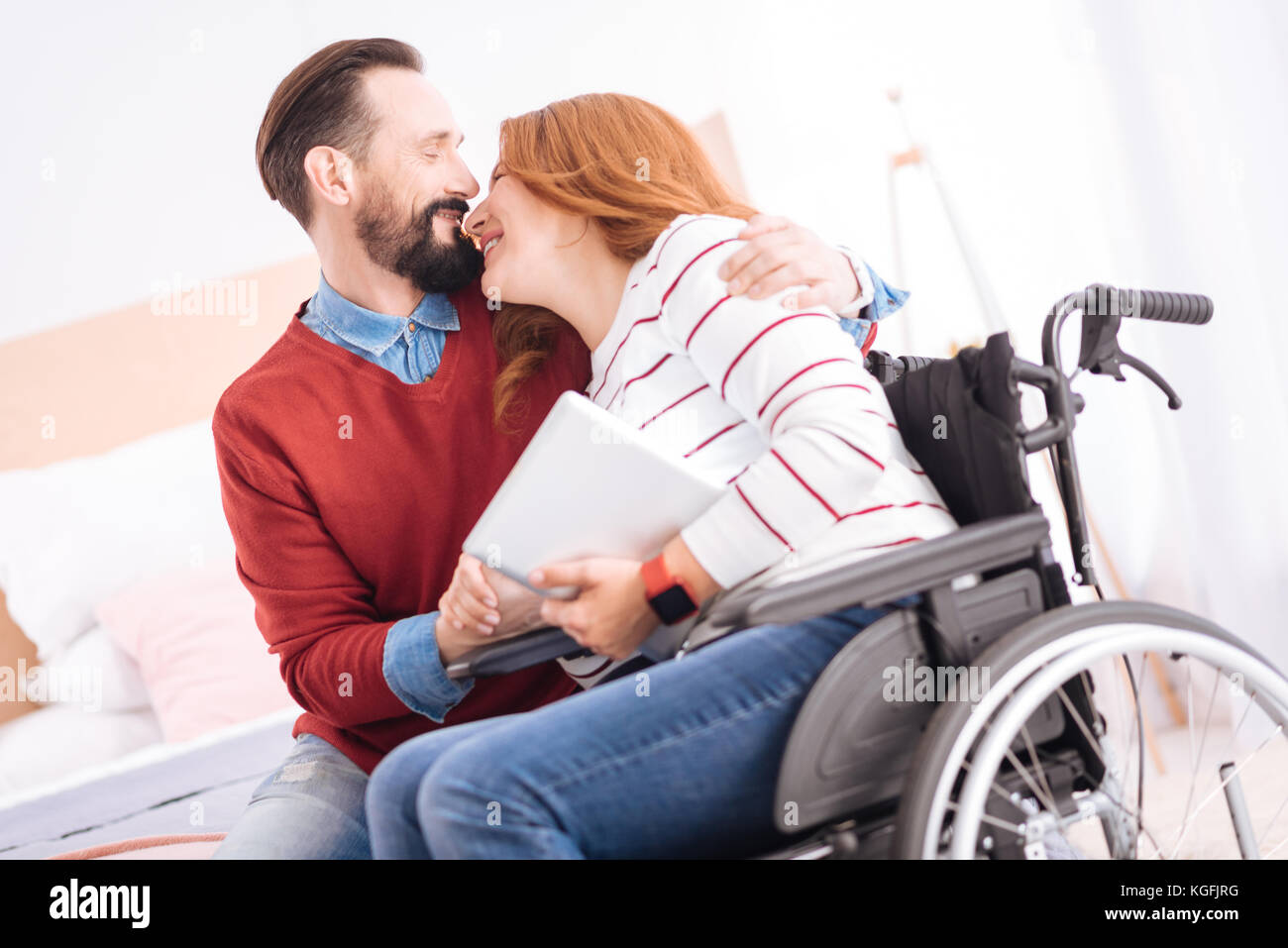 Happy smiling man hugging his disabled woman Stock Photo - Alamy