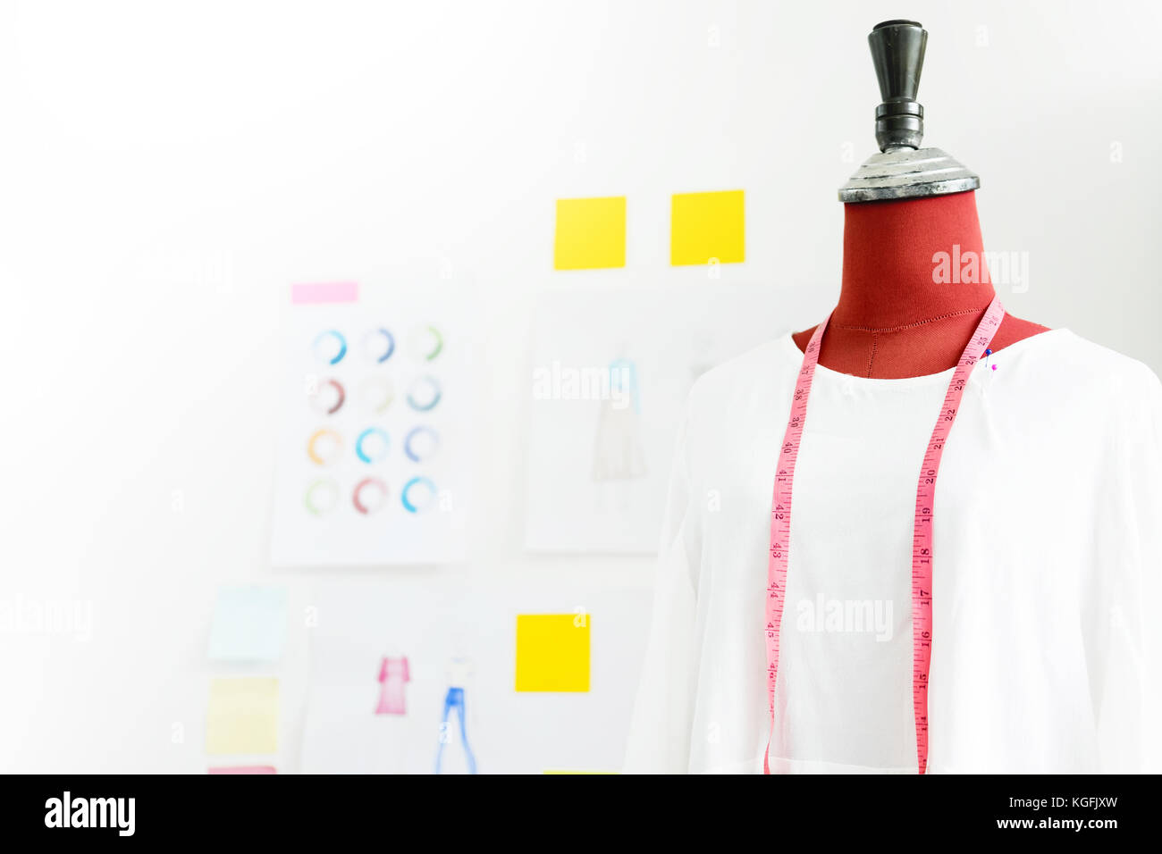 garment design on mannequin Red dummy with measuring tape in tailors ...