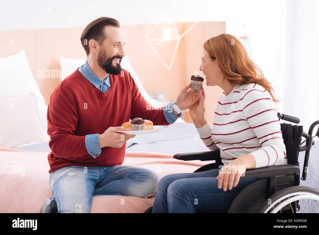 Alert man giving cookies to a paralyzed woman Stock Photo - Alamy