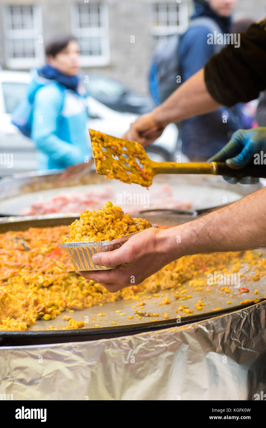 Man serving traditional spanish chicken paella, food market Stock Photo ...